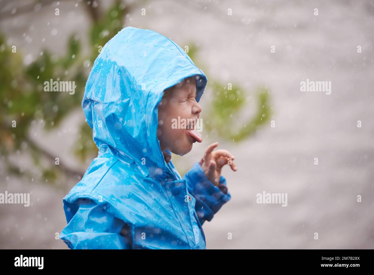 Fun and games in the rain. an adorable little girl playing outside in ...