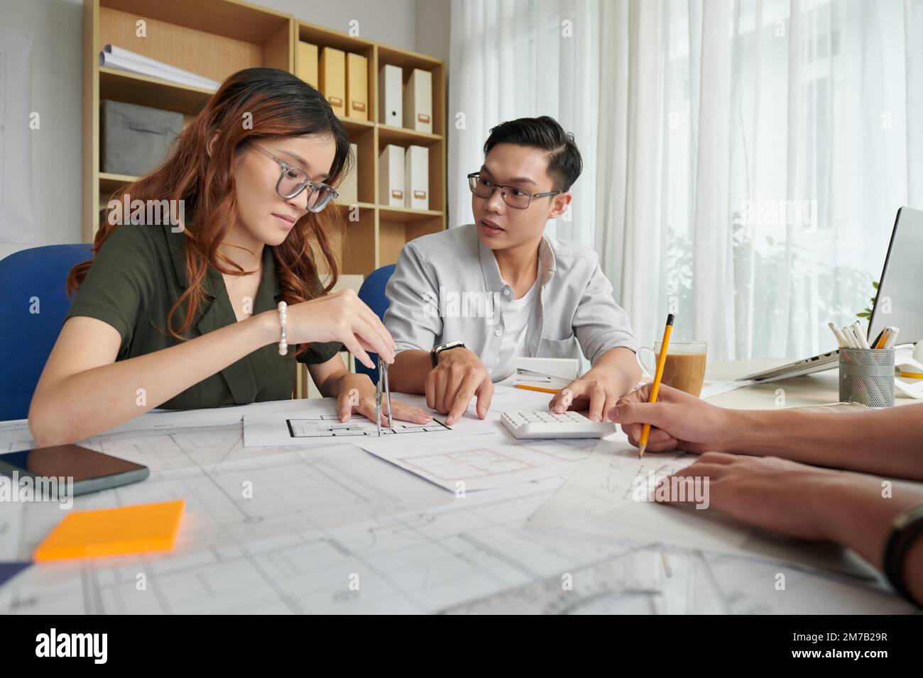 Head architect asking female colleague to double check room dimensions ...