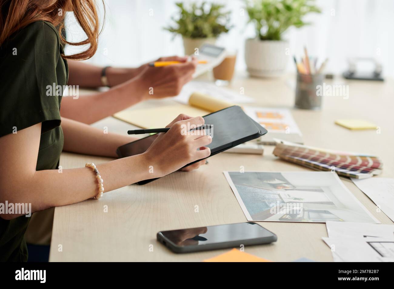 Team of interior designers drawing sketches for new projects on tablet ...