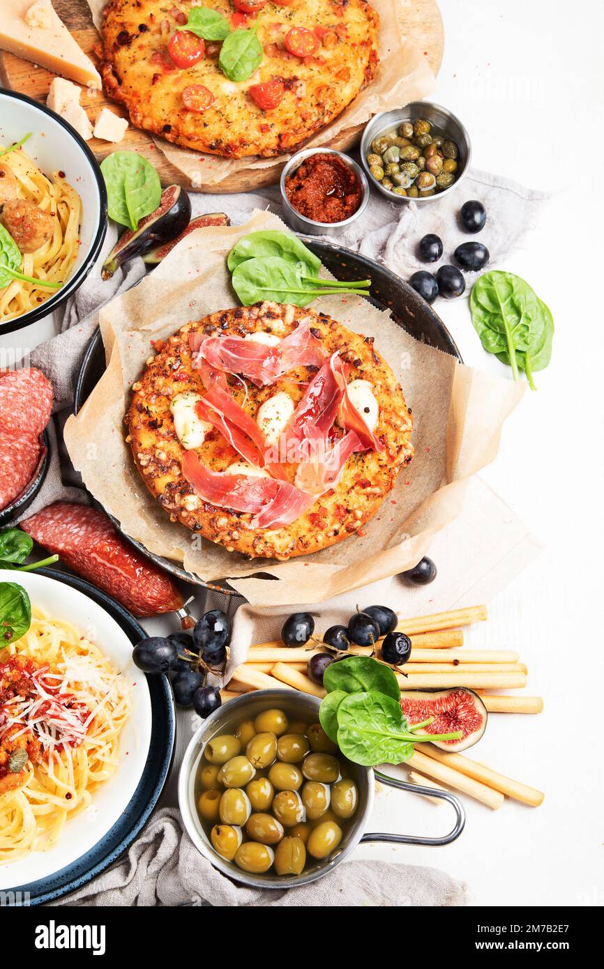 Full table of italian meals on plates and board - Pizza, pasta ...