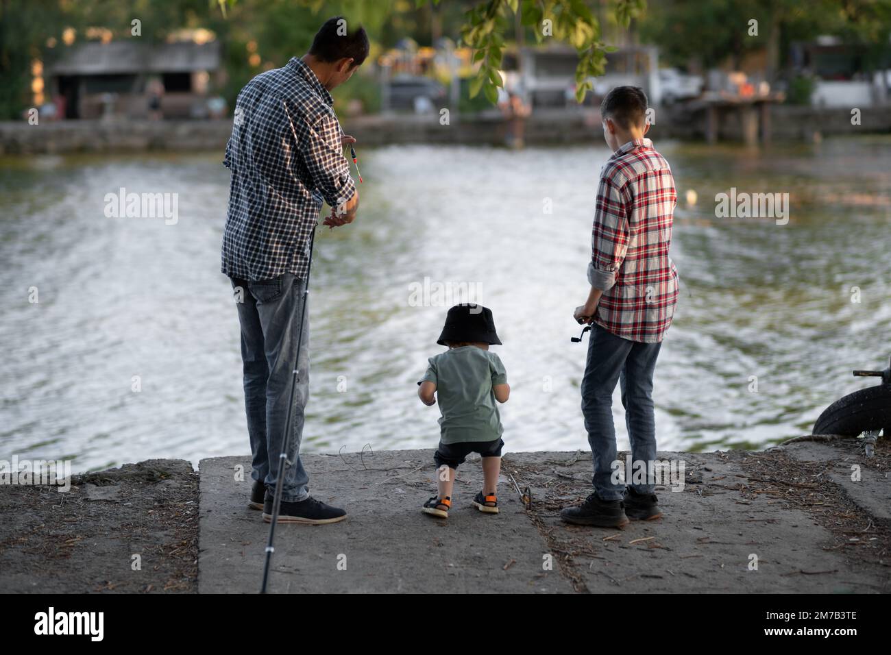 Dad with two sons fishing on the lake Stock Photo - Alamy