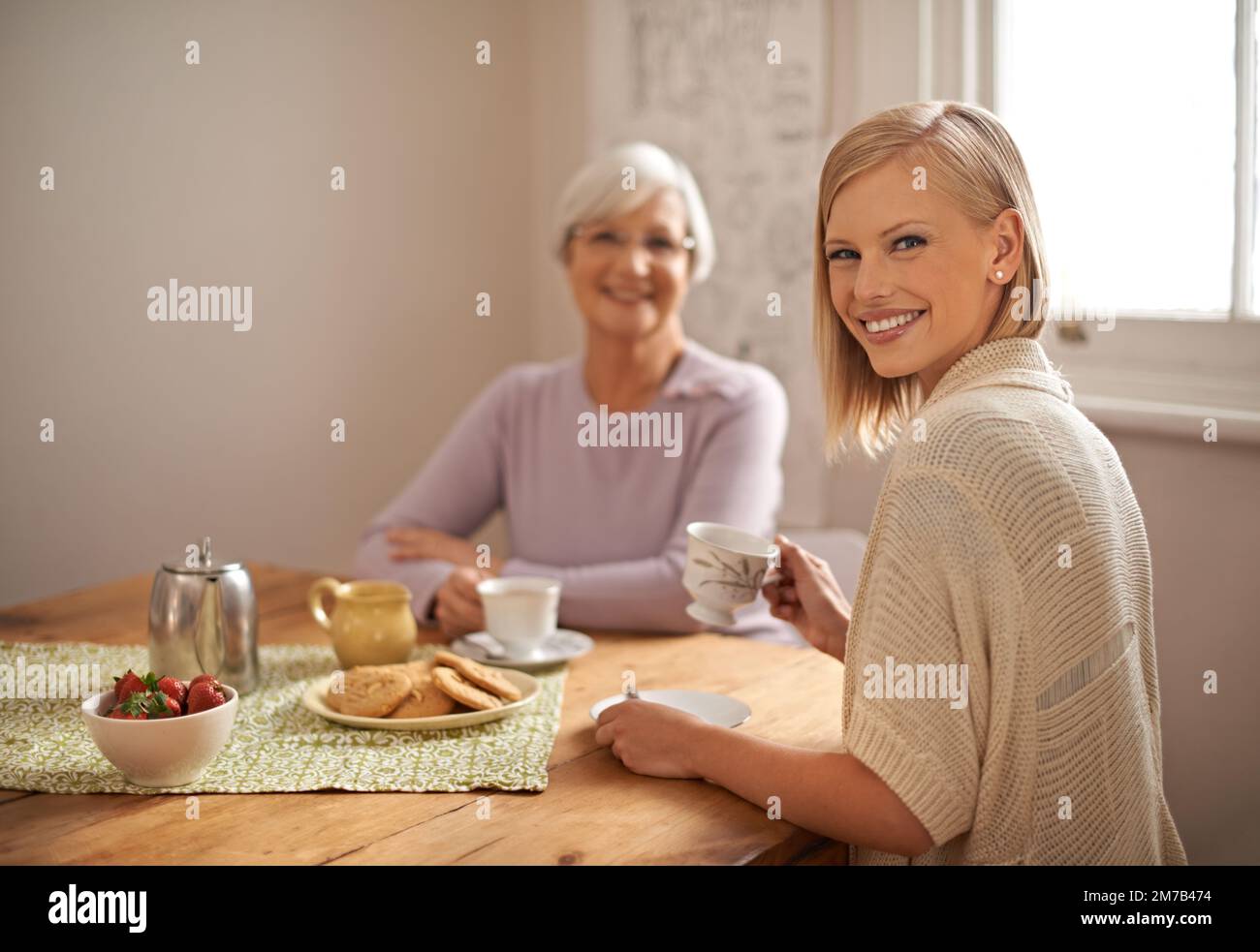 A loving visitor. an attractive young woman visiting her gran for tea ...
