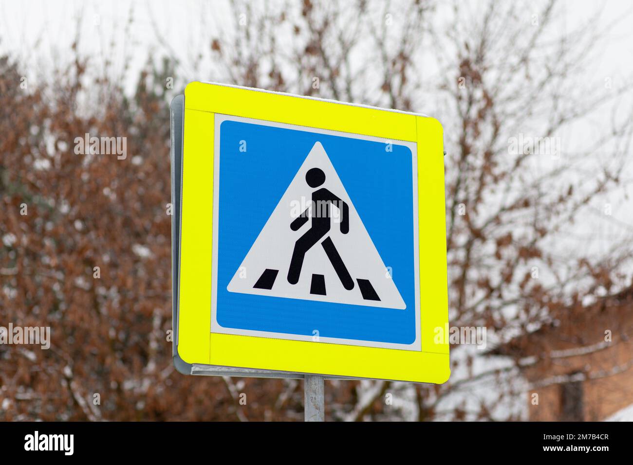 A road sign of a pedestrian crossing in close-up. A sign with a ...