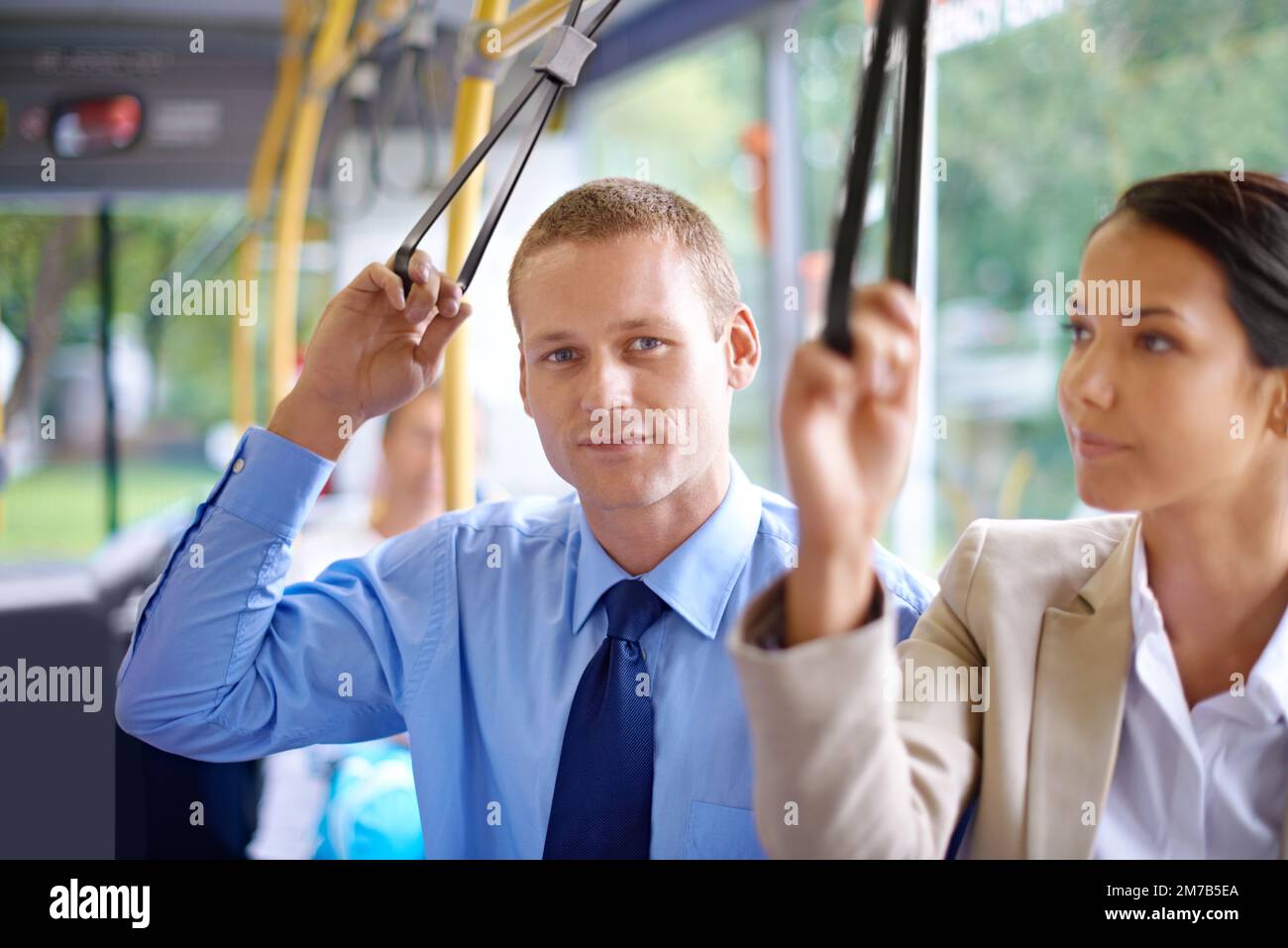 She keeps me company on the commute. Two young colleagues traveling on ...
