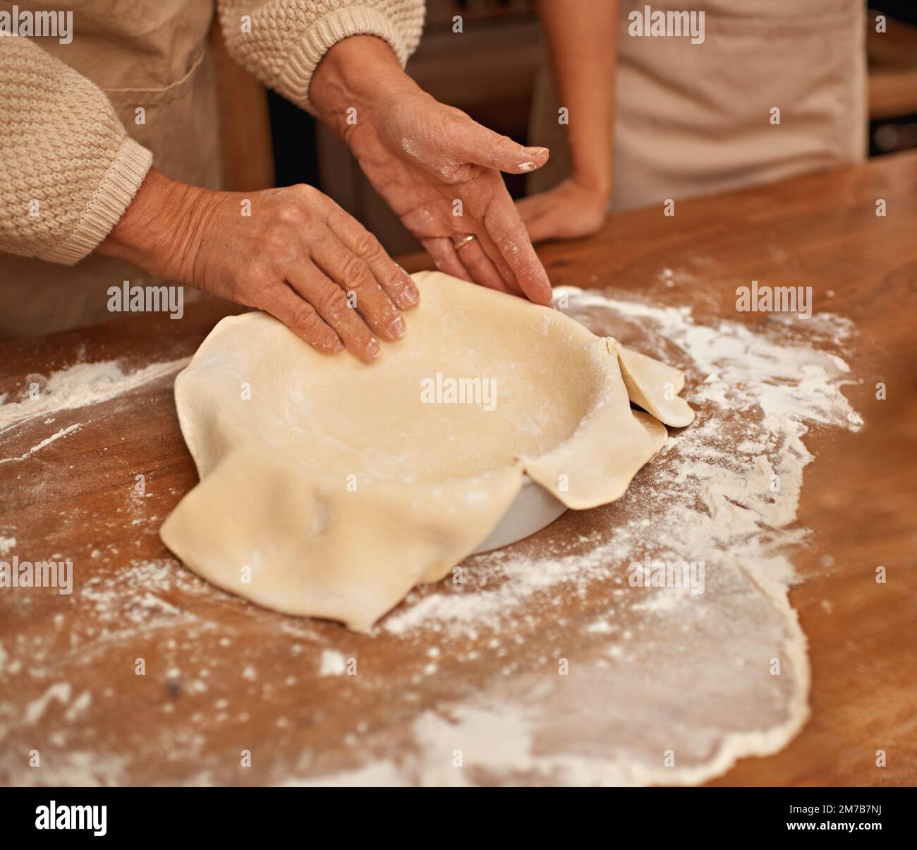 Made with love...A cropped view of hands working the dough while baking ...