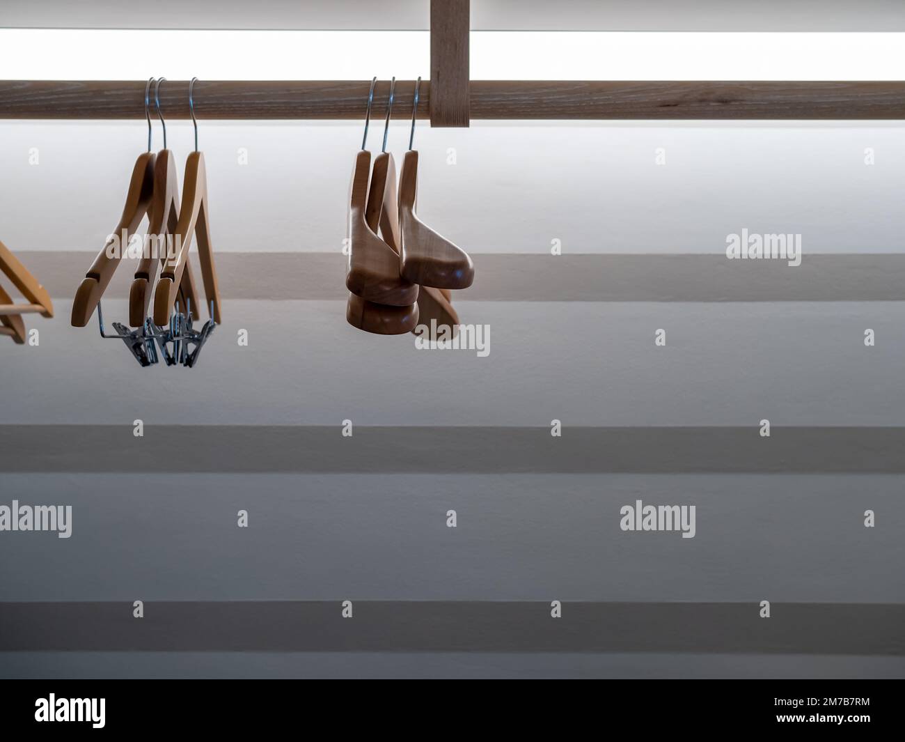 Empty wooden clothes hangers without shirts or dress hanging on a wood ...