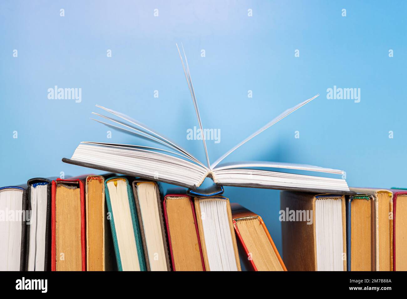 Composition with vintage old hardback books, diary on blue background ...