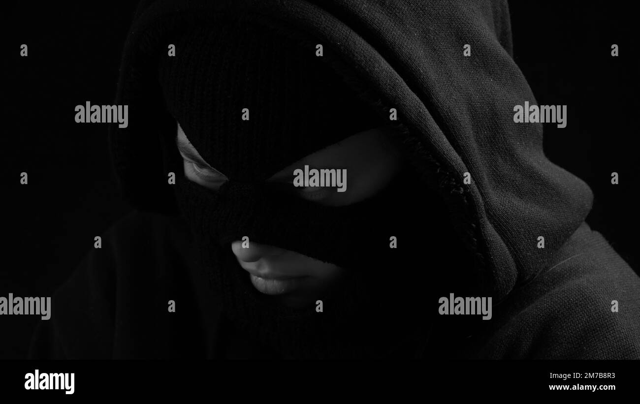Masked female burglar in black look. Crime concept Stock Photo - Alamy