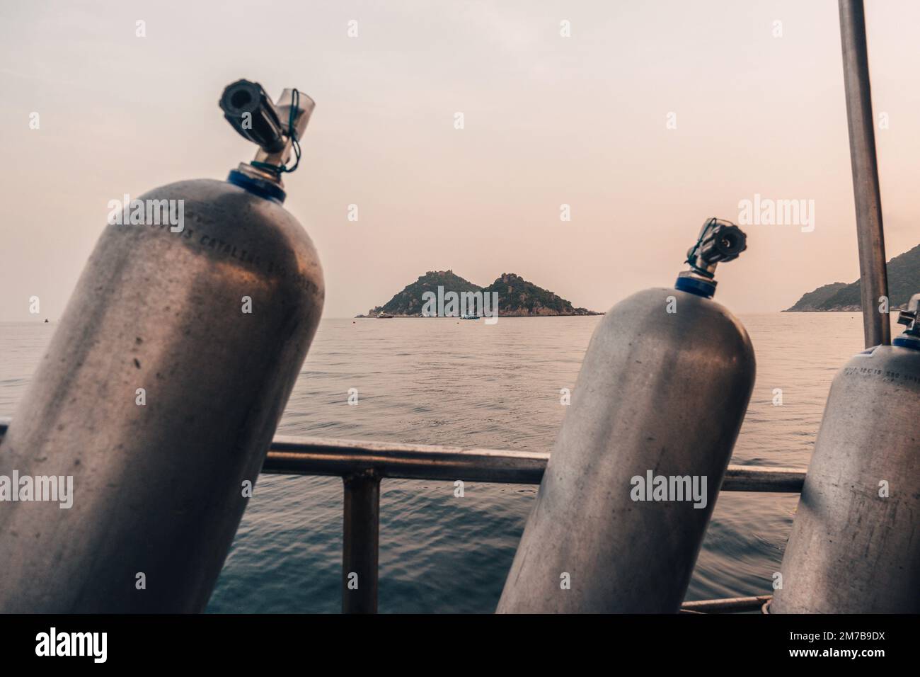 The tank cylinders for scuba diving with a sea and an island in the ...