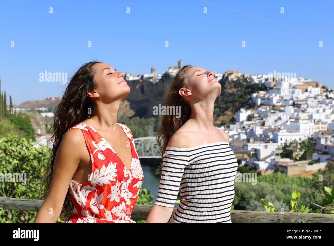 Two relaxed friends on summer vacation breathing fresh air Stock Photo ...
