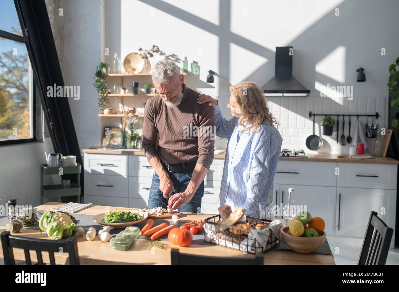 Mature couple feeling good while cooking together in the kitchen Stock ...