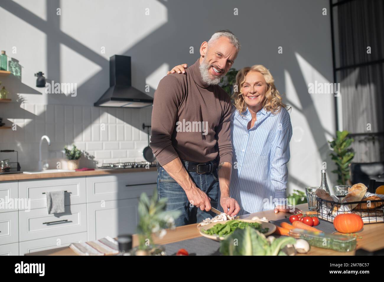 Mature couple feeling good while cooking together in the kitchen Stock ...