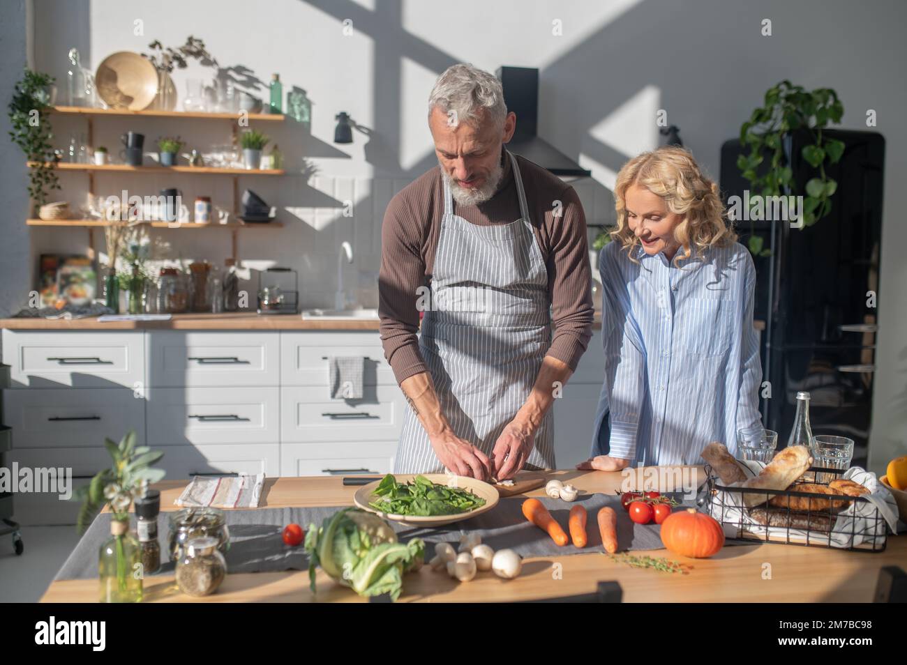 Man and woman cooking together in the kitchen Stock Photo - Alamy