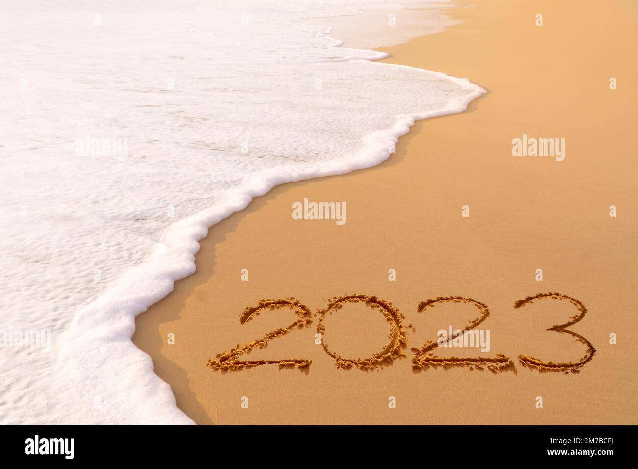 Welcoming The year 2023 handwriting on sand beach, Happy New Year ...