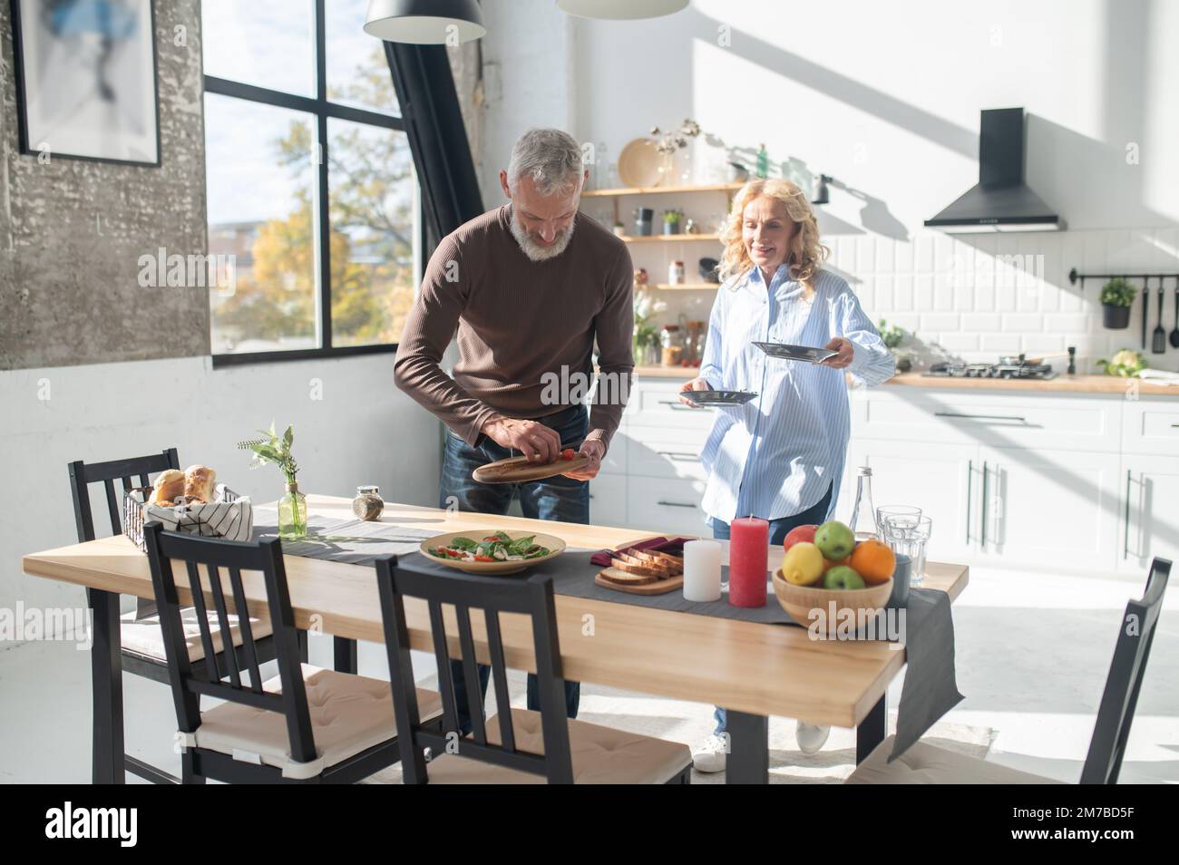 Man and woman serving the table for dinner Stock Photo - Alamy