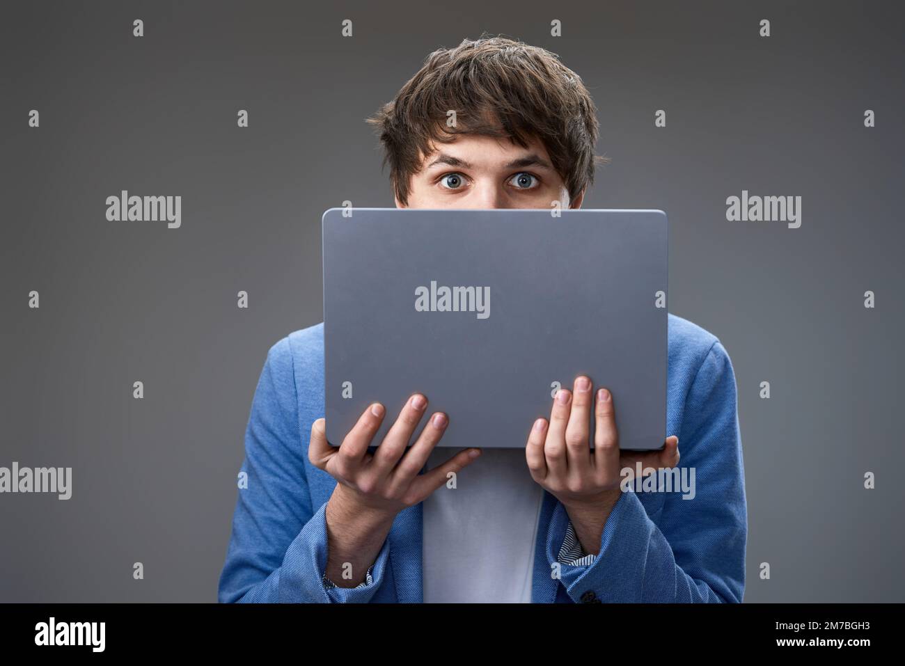 Young amazed man hiding hi-res stock photography and images - Alamy