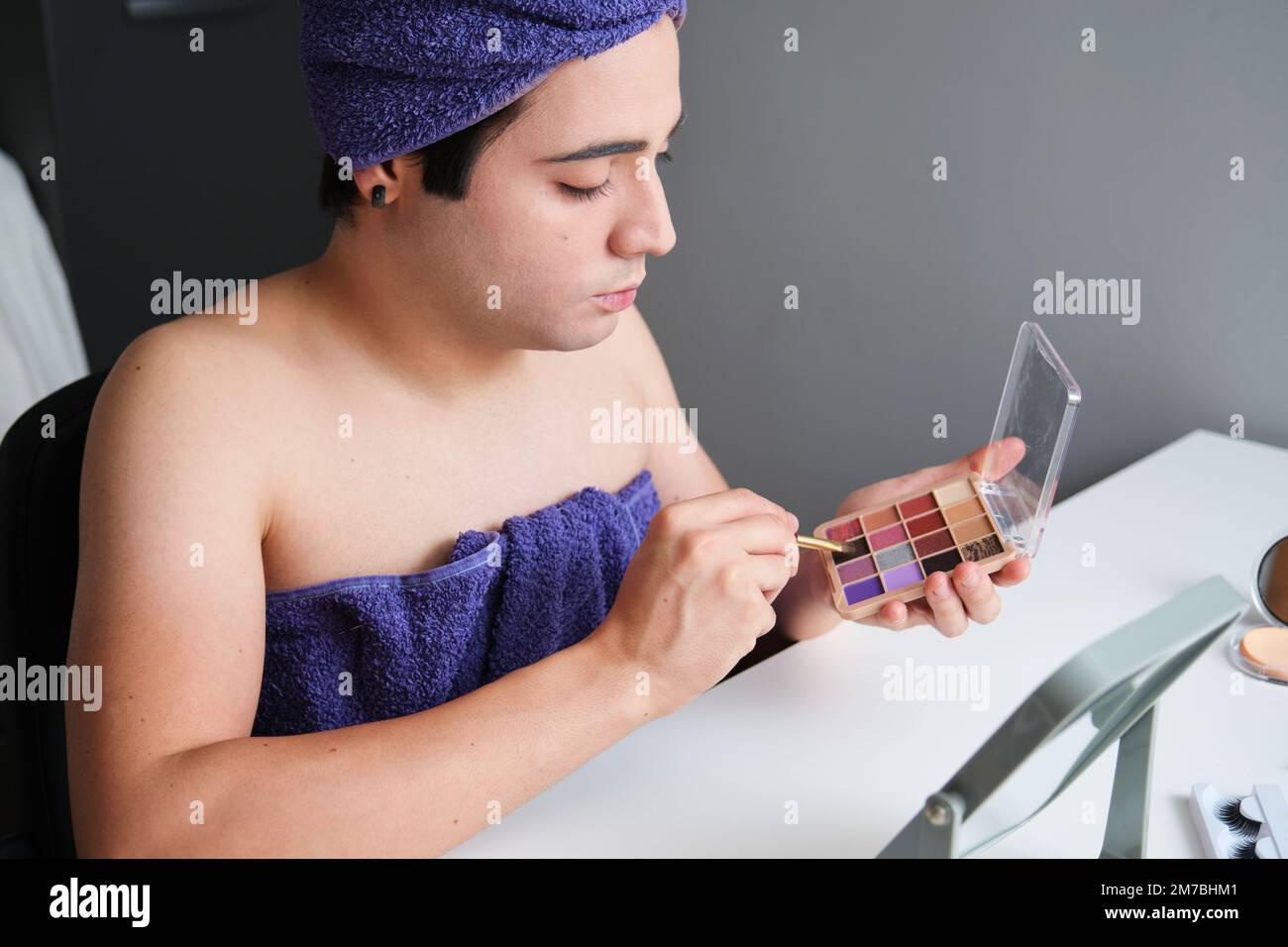 Young transgender man choosing the right color of eyeshadow Stock Photo ...