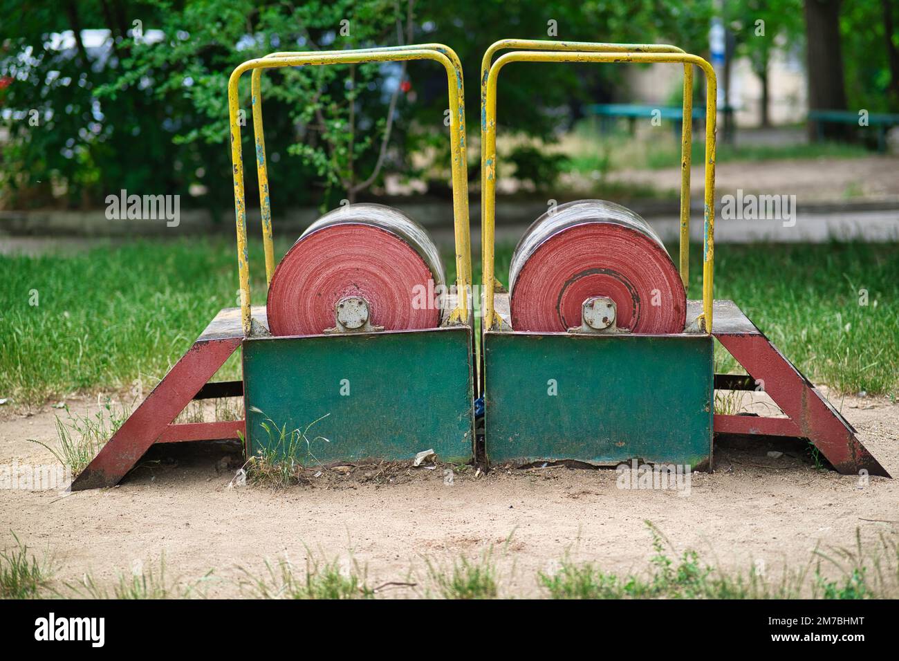 The wheels with metal handrails on an old Soviet-era playground in ...