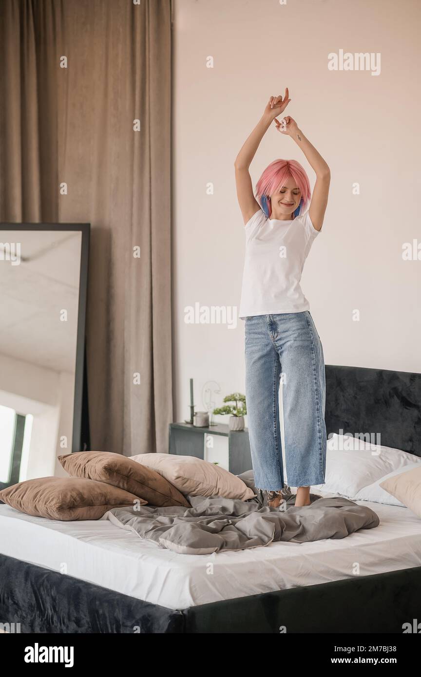 Smiling happy young lady dancing in the bedroom Stock Photo - Alamy