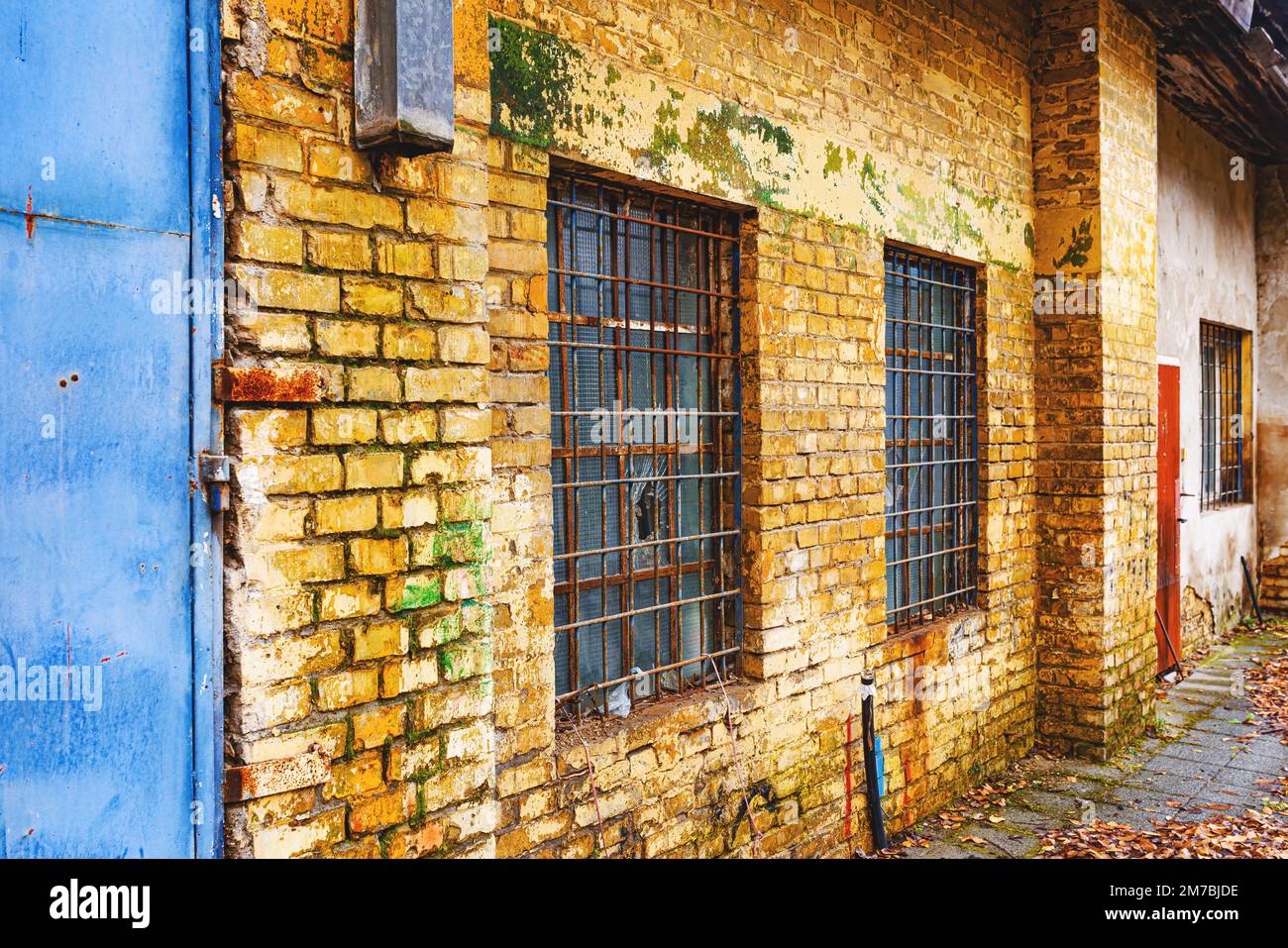 Old grid windows with broken glass on exterior wall of an old abandoned ...