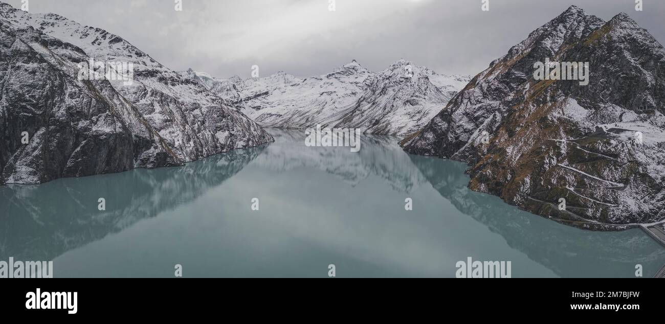 Amazing drone footage over an alpine lake, hydro dam and vast Alpine ...