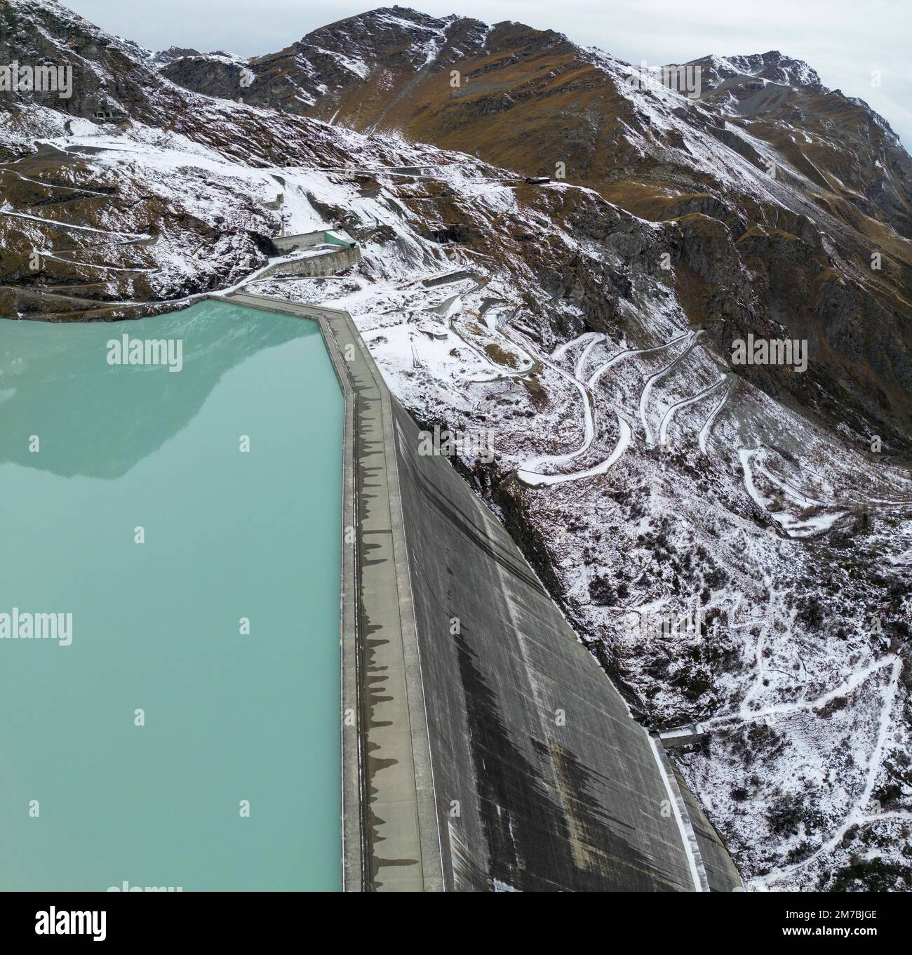 Amazing drone footage over an alpine lake, hydro dam and vast Alpine ...