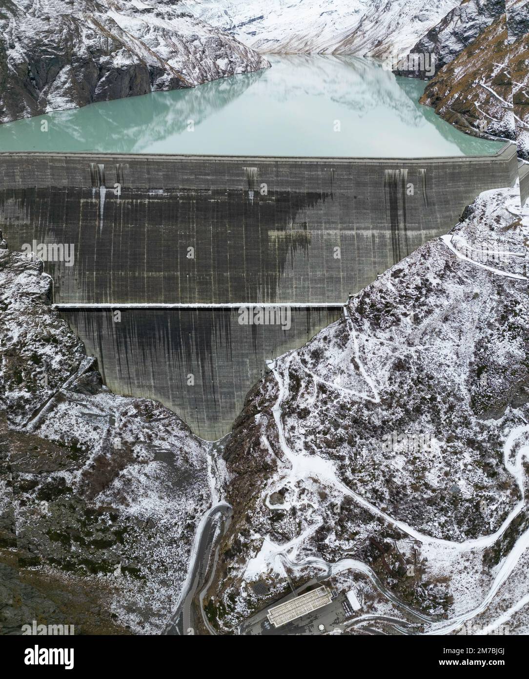 Amazing drone footage over an alpine lake, hydro dam and vast Alpine ...