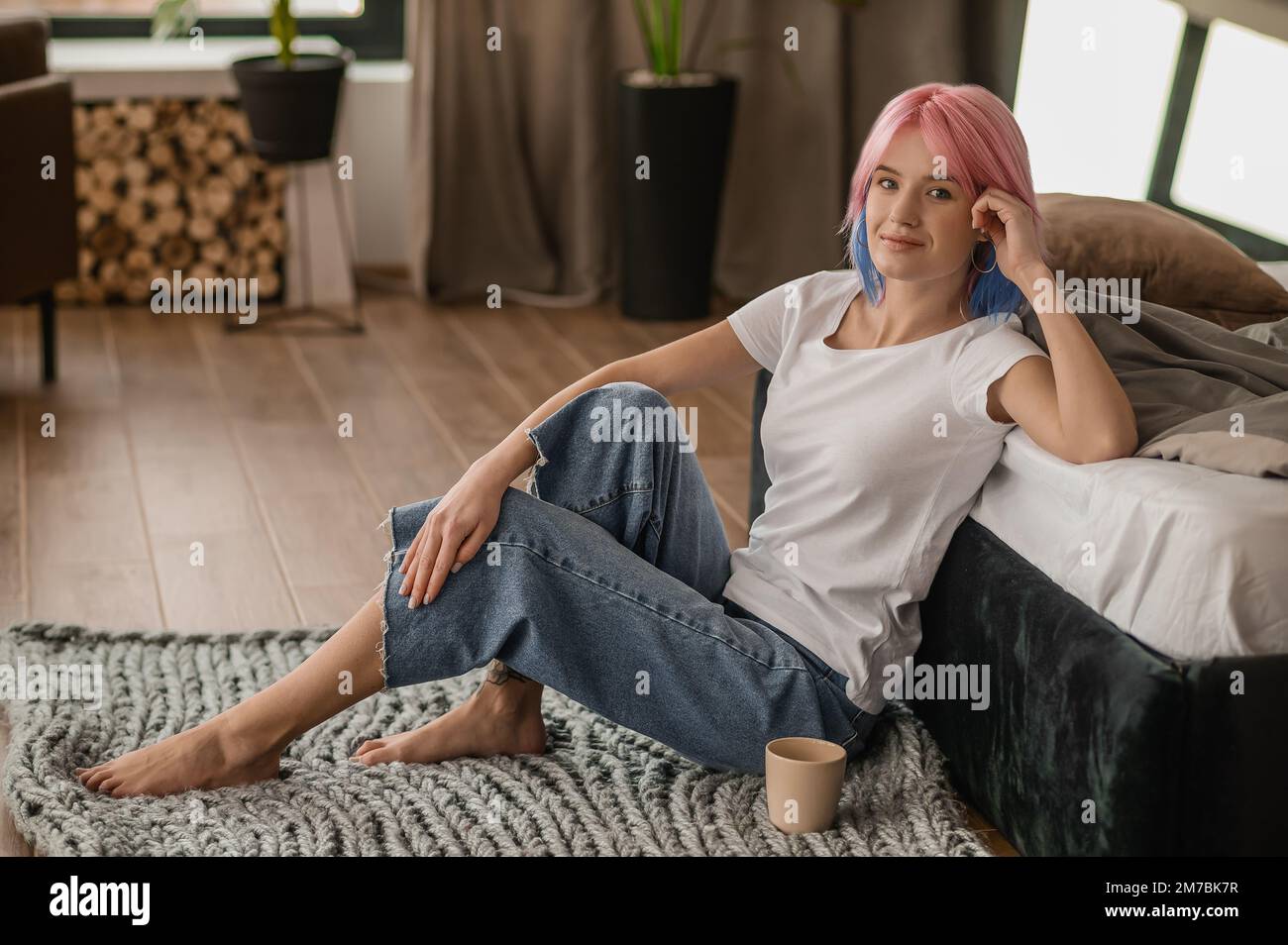 Modern girl whiling away the time in the bedroom Stock Photo - Alamy