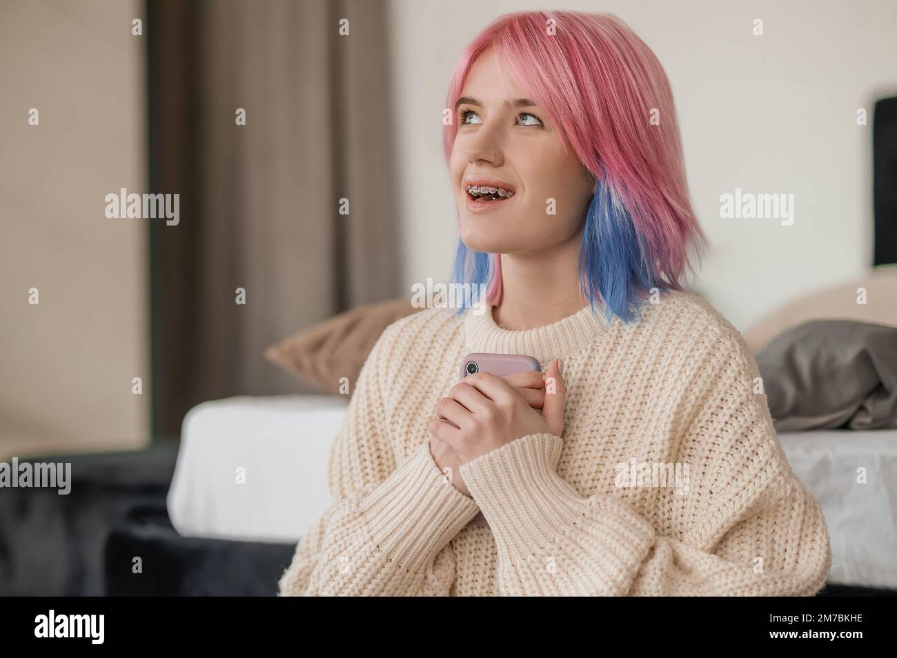 Pleased young woman with the mobile phone Stock Photo - Alamy