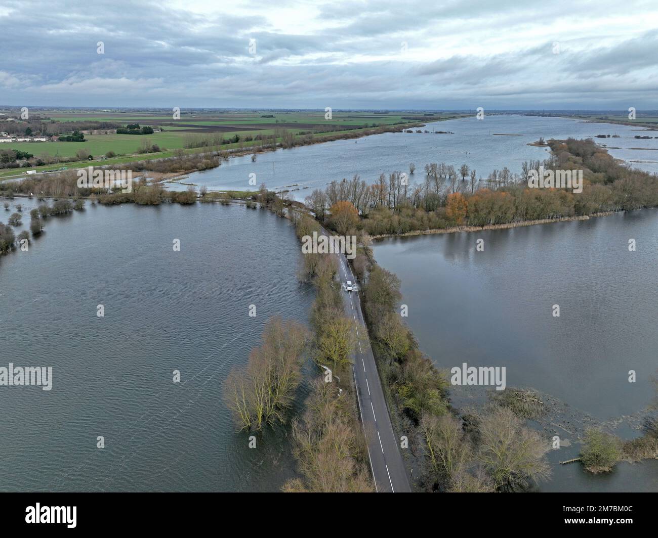 A vehicle travels along the road as the Welney wash fills with ...