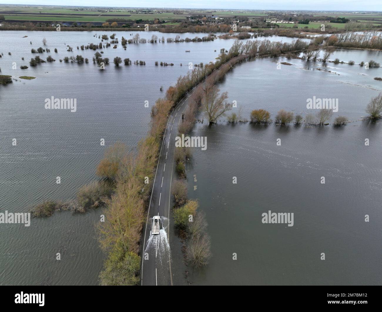 A truck travels along the road as the Welney wash fills with floodwater ...