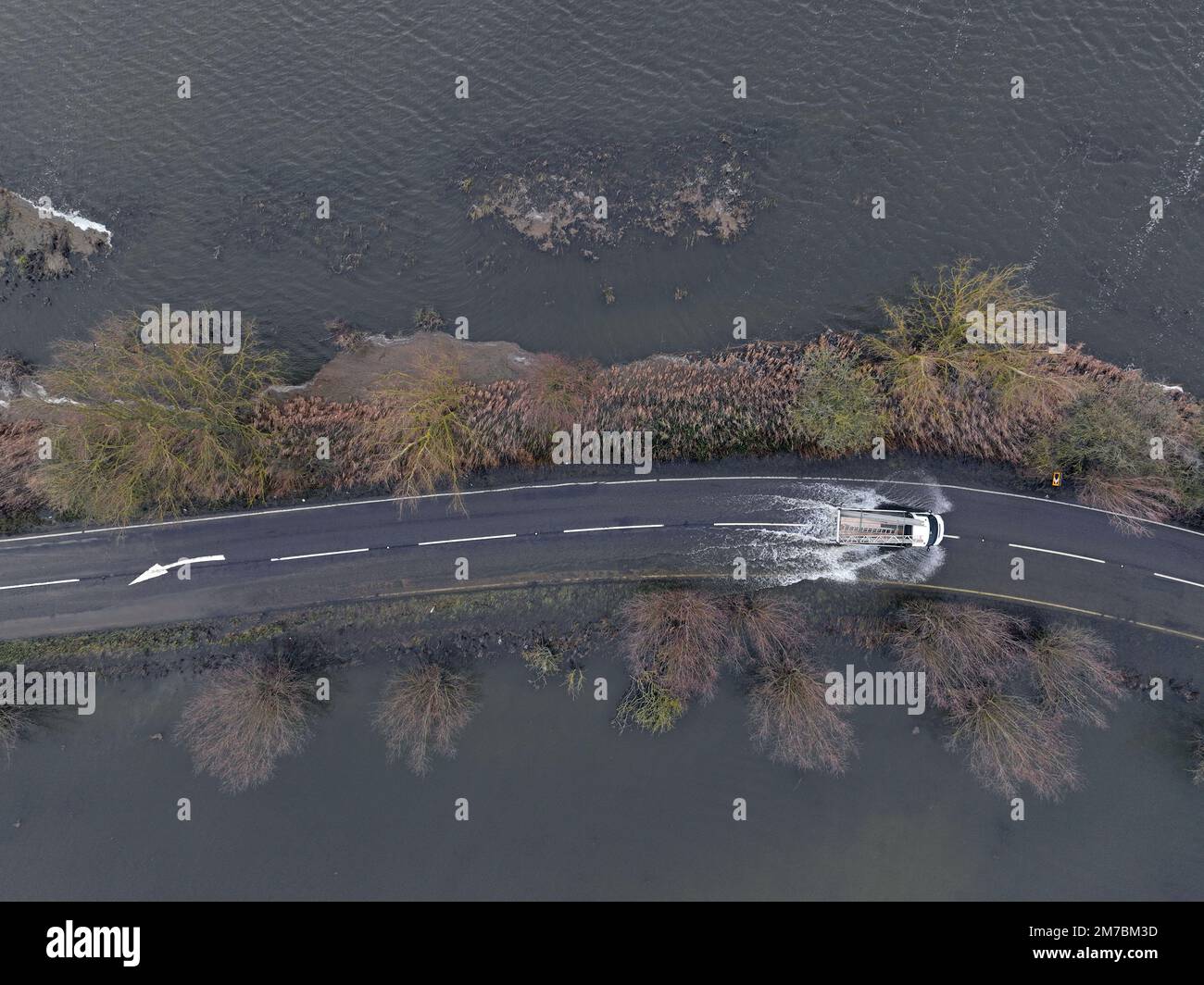 A truck travels along the road as the Welney wash fills with floodwater ...