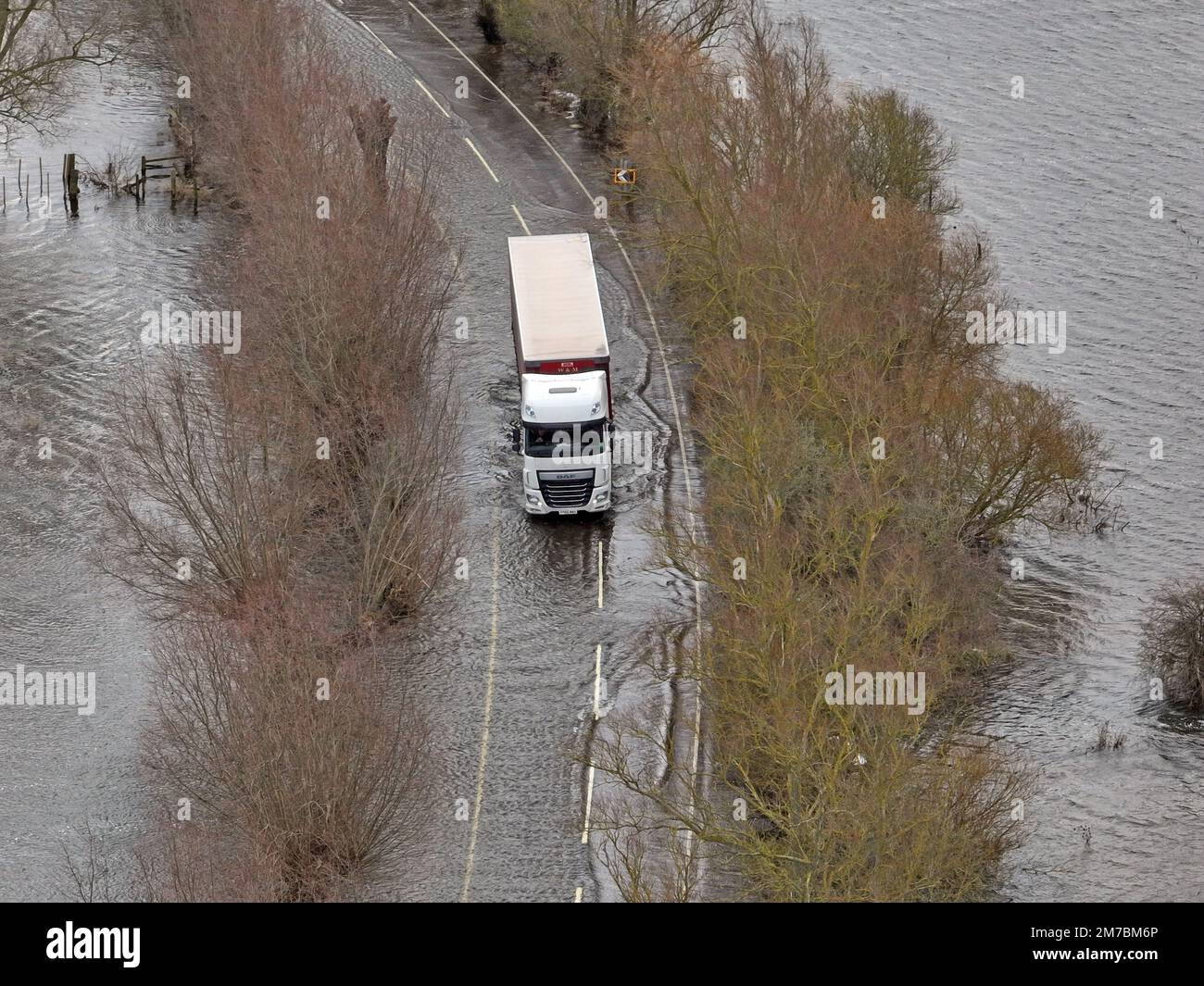 A lorry travels along the road as the Welney wash fills with floodwater ...
