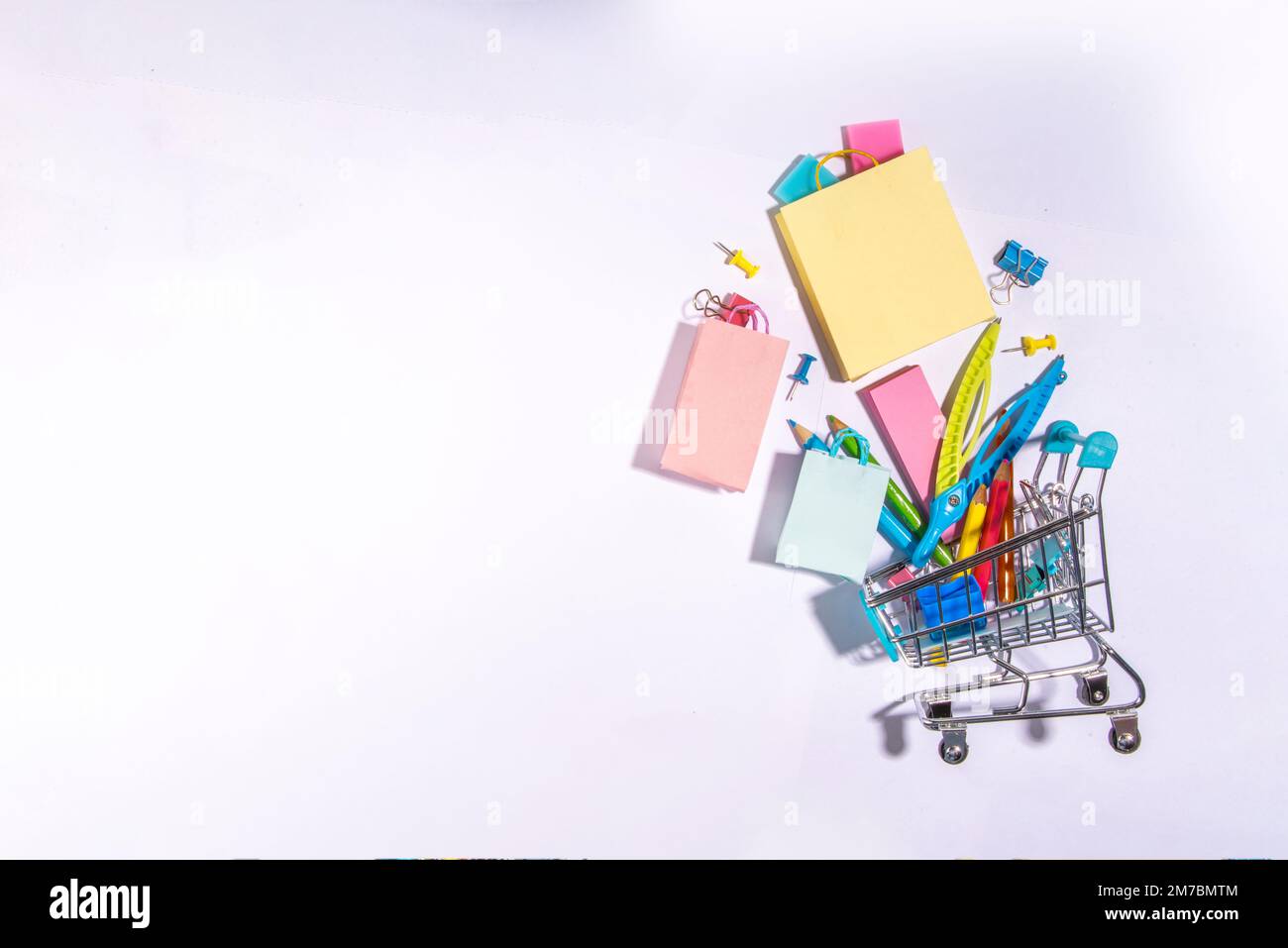 School sale concept. Shopping supermarket cart with colorful paper bags ...