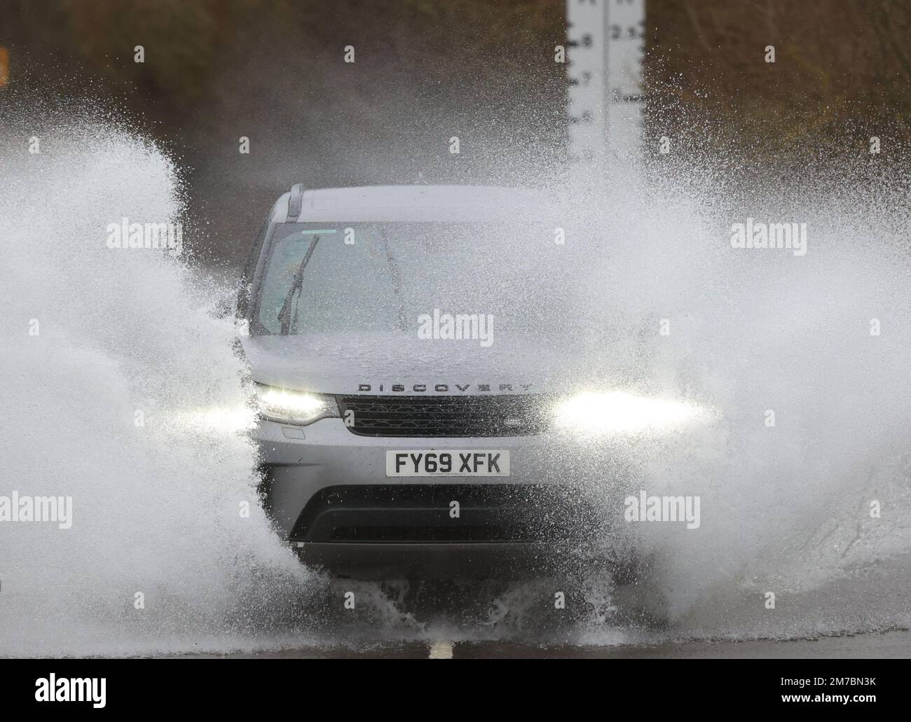 A car makes a splash as The Welney wash fills with floodwater and the ...