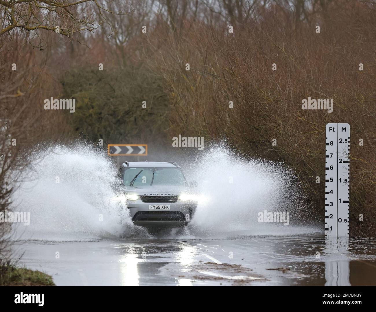 A vehicle makes a splash as The Welney wash fills with floodwater and ...