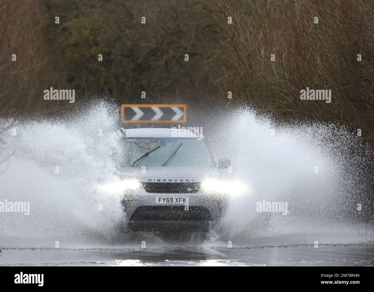 A car makes a splash as The Welney wash fills with floodwater and the ...