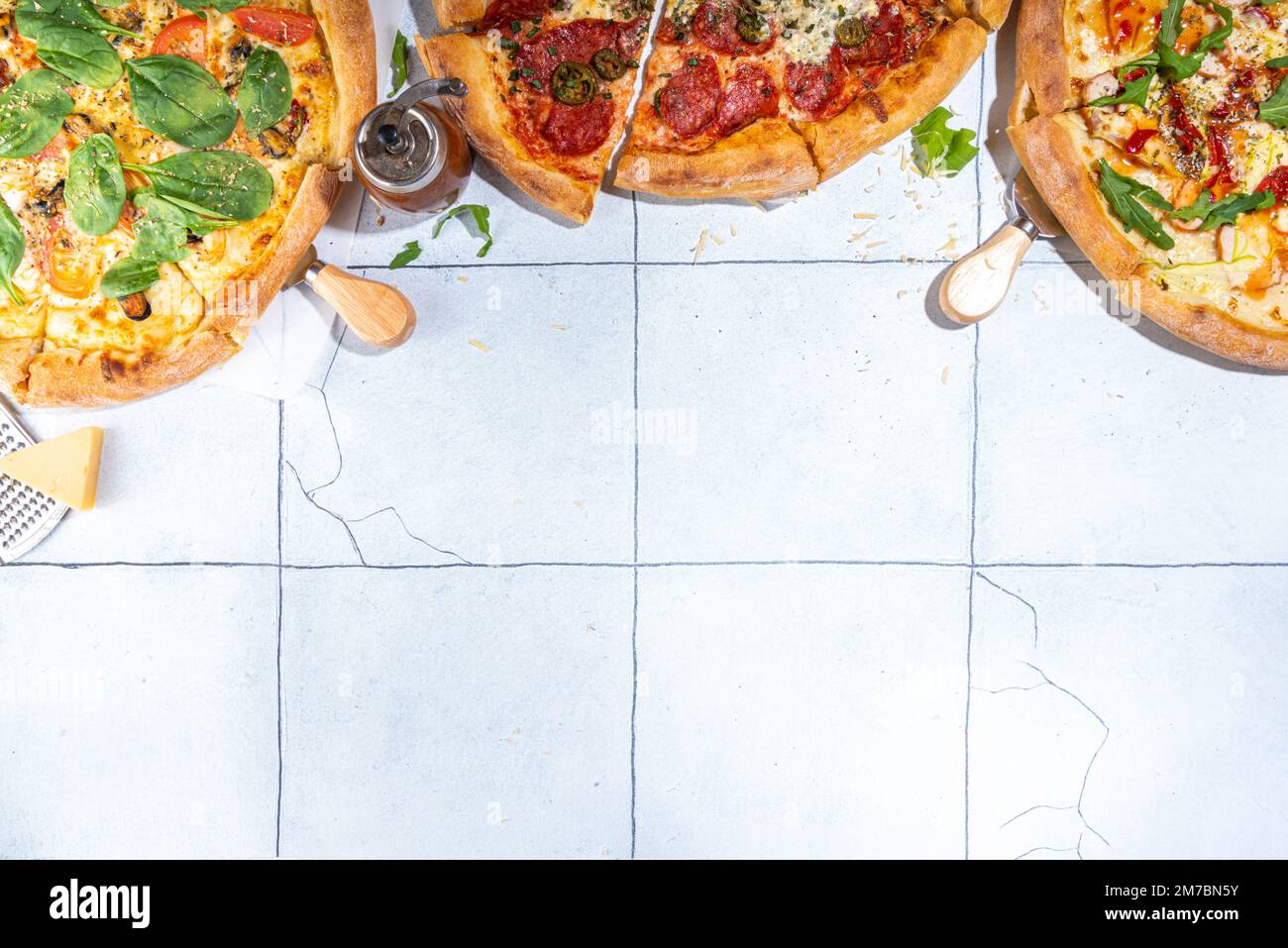 Three various pizzas, served at home or in restaurant on tiled table ...