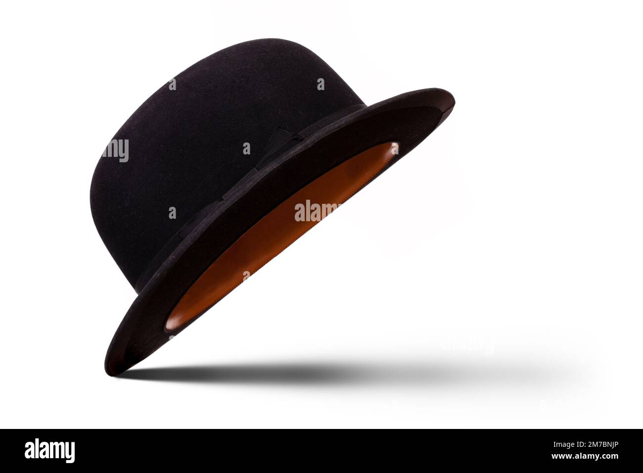 Black bowler hat tilted to see underneath with shadow isolated on white ...