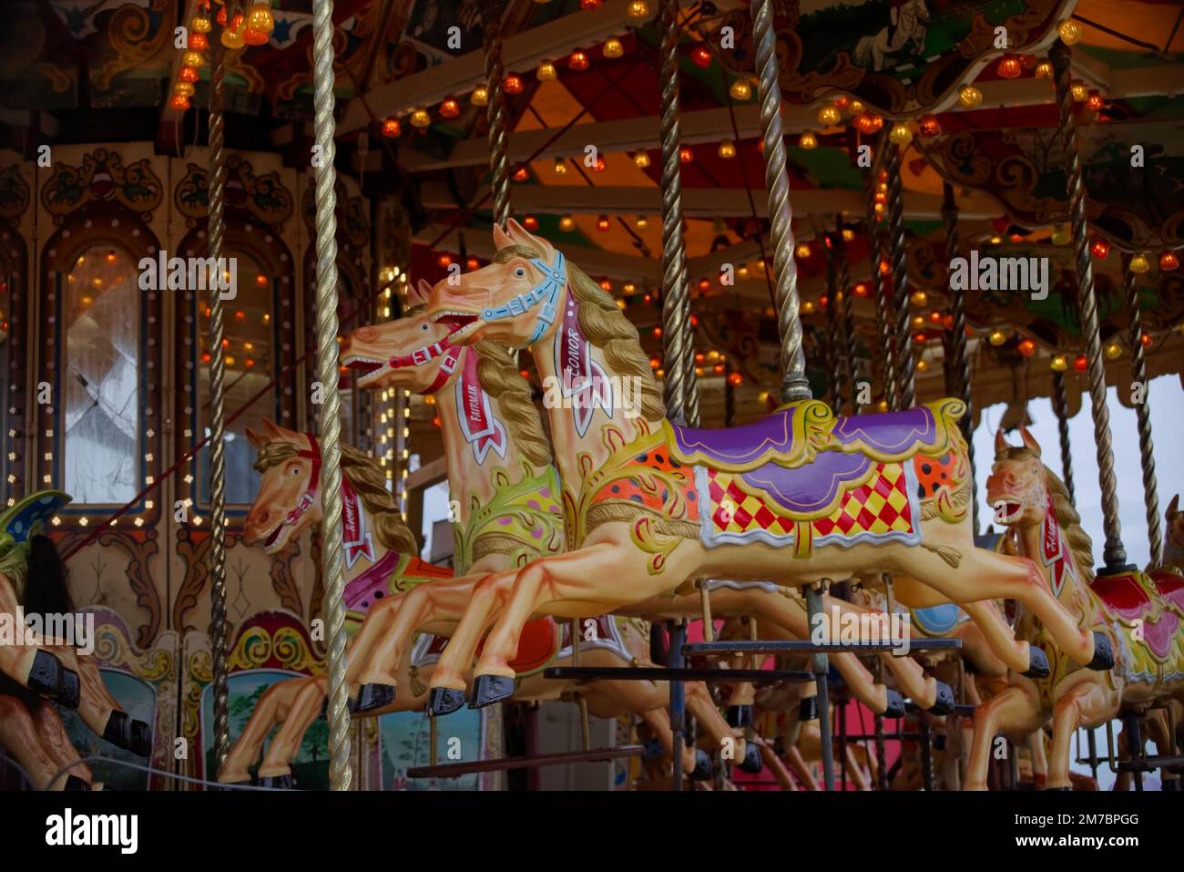 Empty horse-shaped seats on vintage merry-go-round ready to ride at the ...