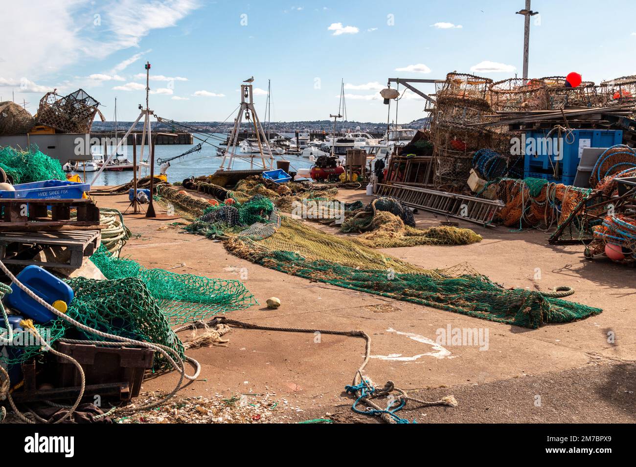 A working fishing port at Torquay Harbour in Devon, UK. On the dock are ...