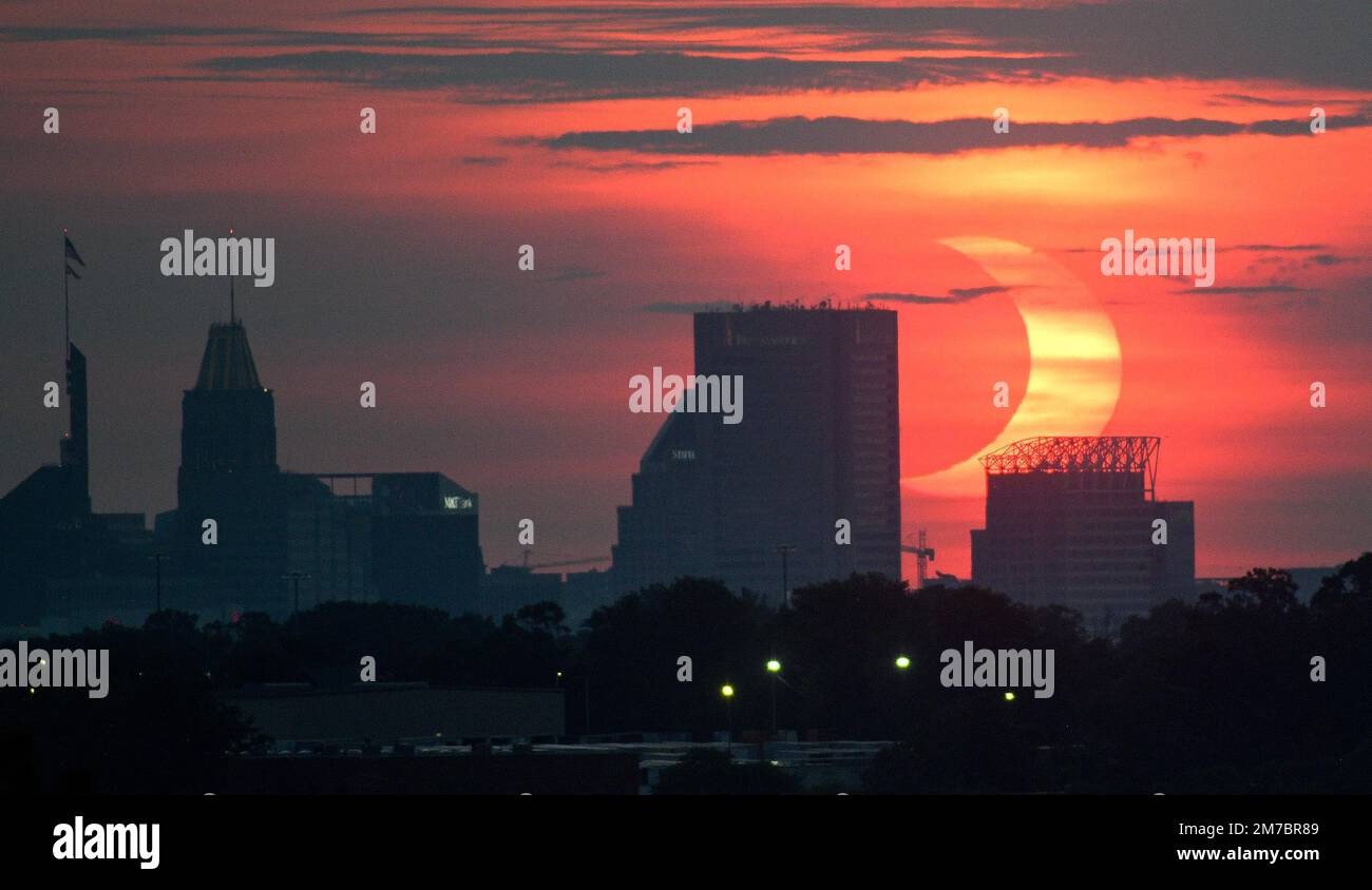 The sun and moon rise together over downtown Baltimore in partial ...