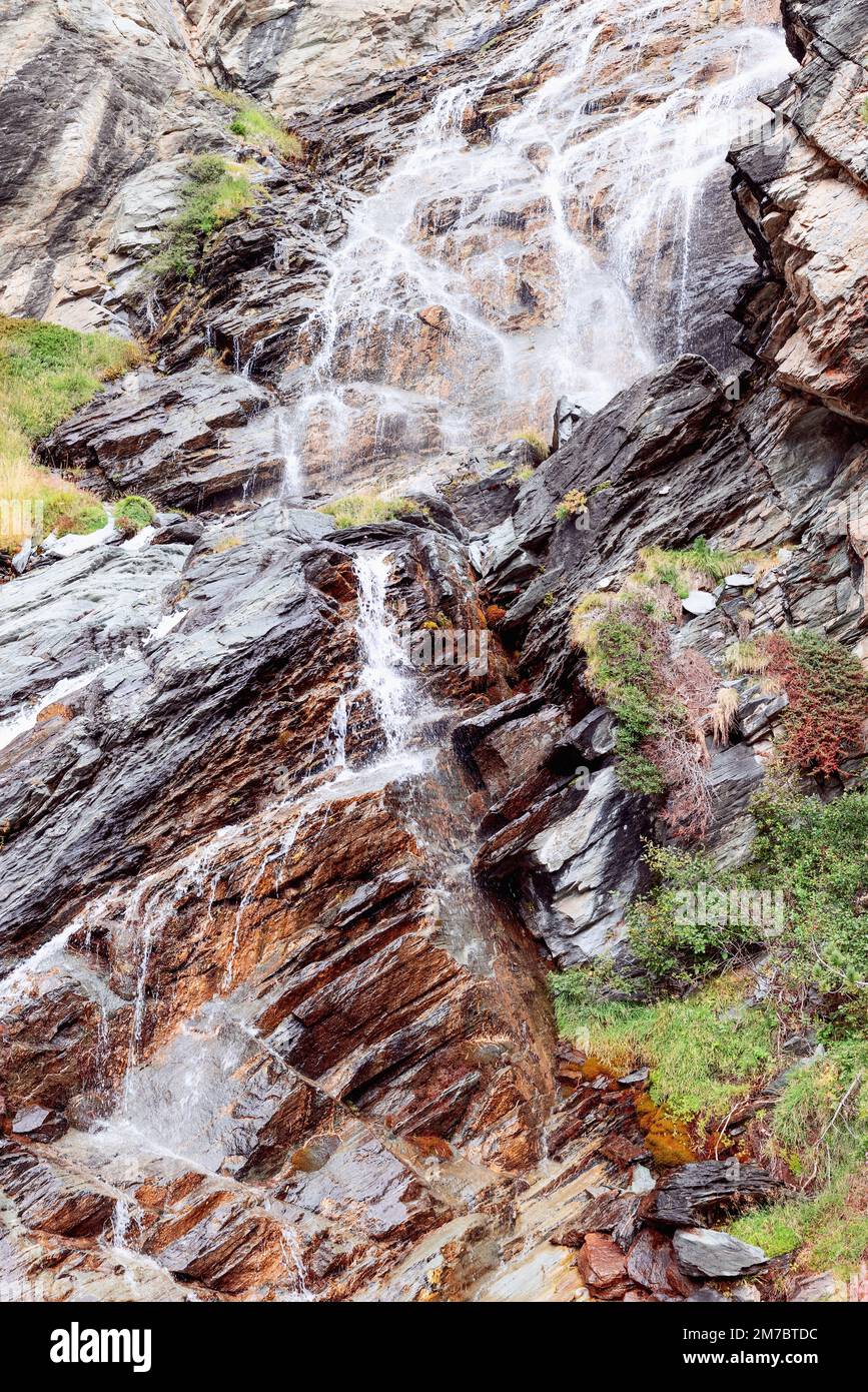 Alpine flowing waterfall washes various color karst overlays of granite ...