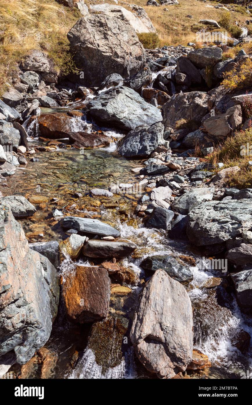Small pond of crystal clear water with pebbles, sand and cobblestones ...