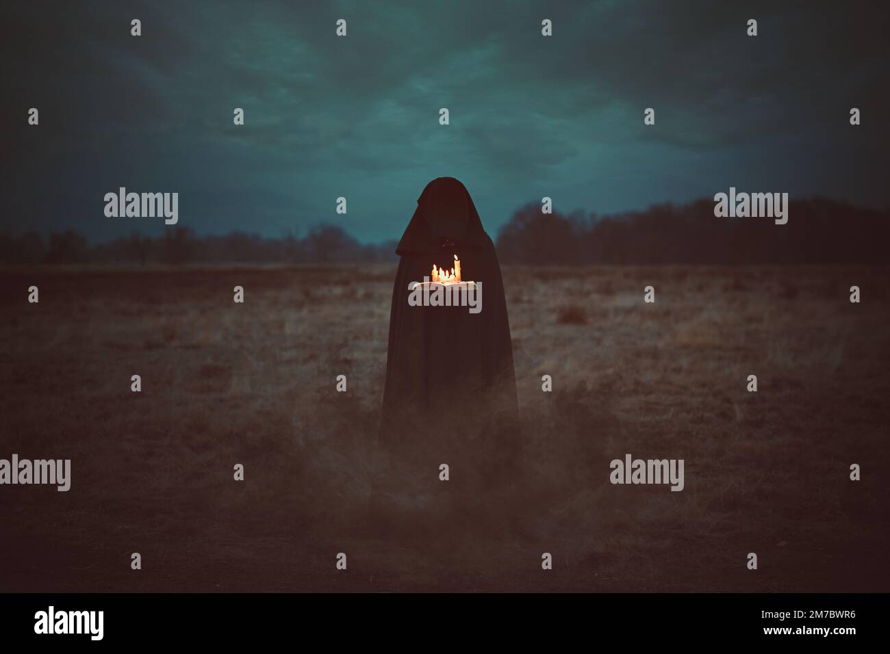 Black wizard with magical book Stock Photo - Alamy