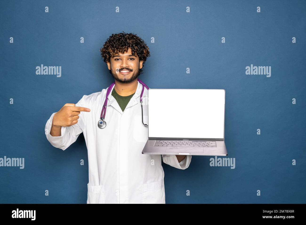 Profile photo, Indian male doctor using laptop, standing isolated over ...