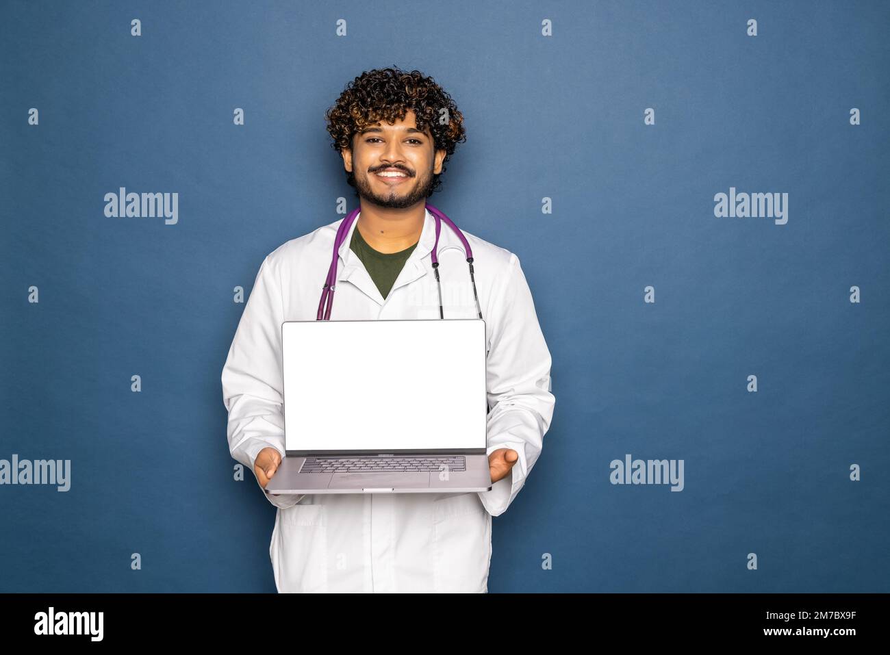 Profile photo, Indian male doctor using laptop, standing isolated over ...
