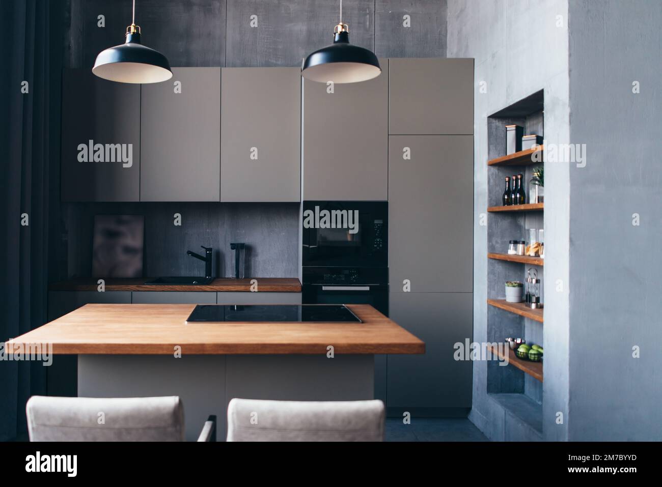 Modern kitchen with table and built-in hob Stock Photo - Alamy