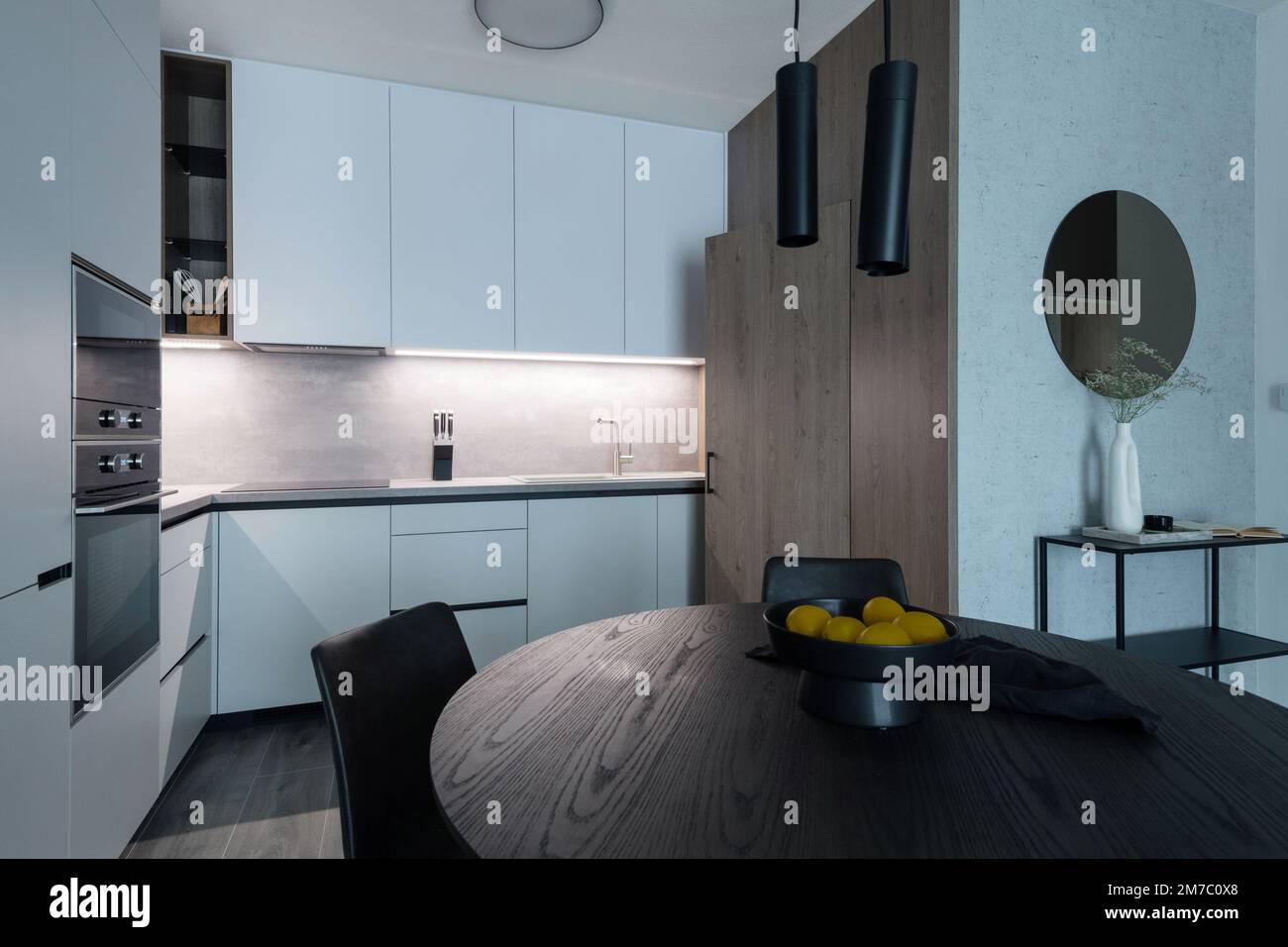 Kitchen with built in appliances and dining table of modern apartment ...