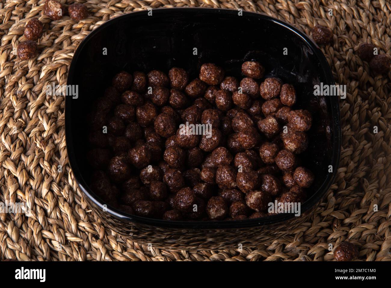 photo of glazed balls in a square black plate on a woven napkin in ...
